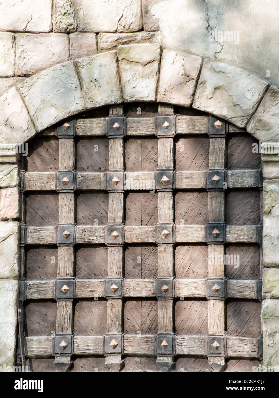 Massive old wooden gate with arch in wall made of large stones Stock ...