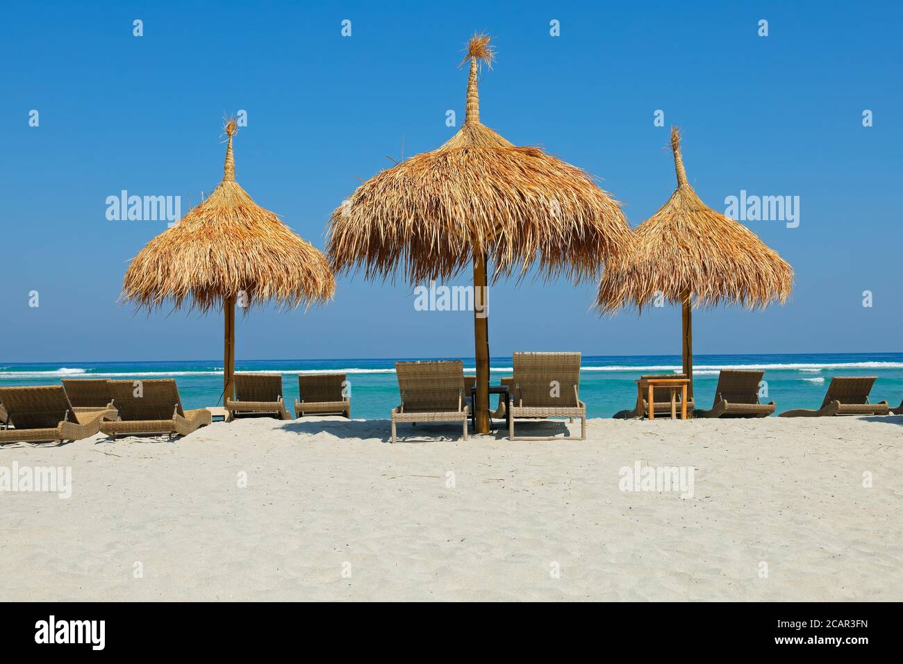 Thatched shades on a scenic tropical island beach, Bali, Indonesia ...