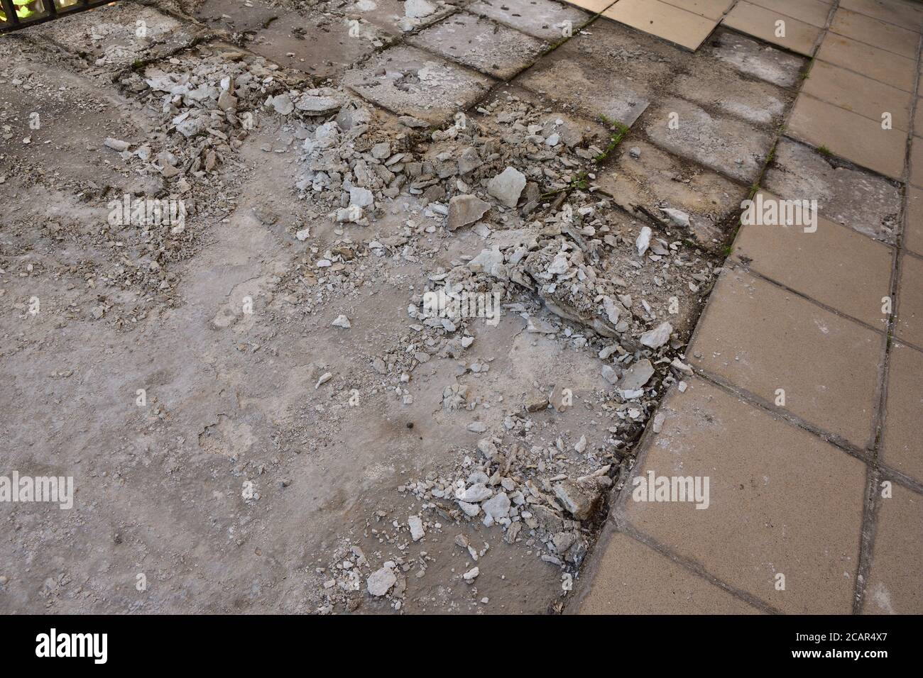 Chipping off old tiles on the terrace during renovation, replacing them ...