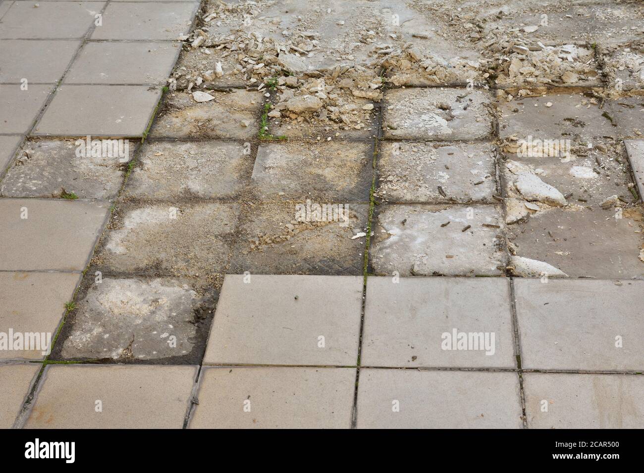 Chipping off old tiles on the terrace during renovation, replacing them ...