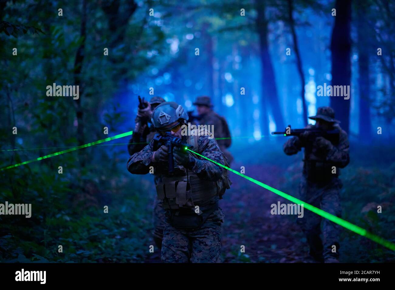 soldiers squad in action on night mission using laser sight beam lights ...