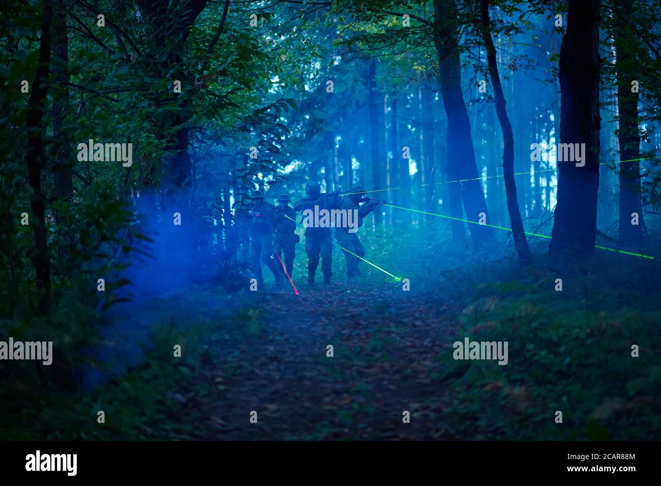 soldiers squad in action on night mission using laser sight beam lights ...