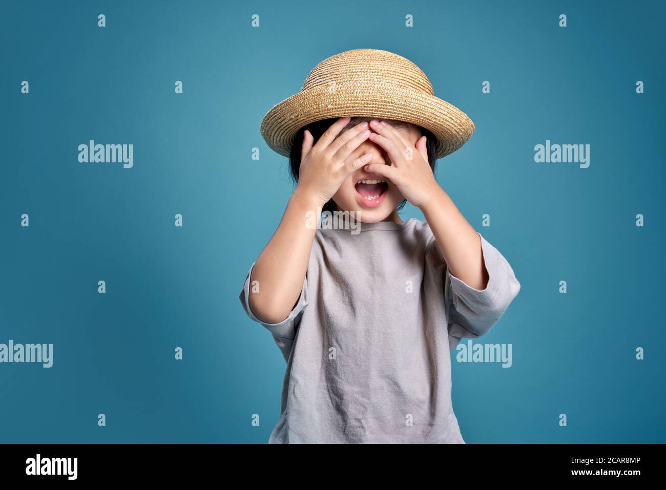 Happy asian little kid blocking face with both hand. Empty space in ...