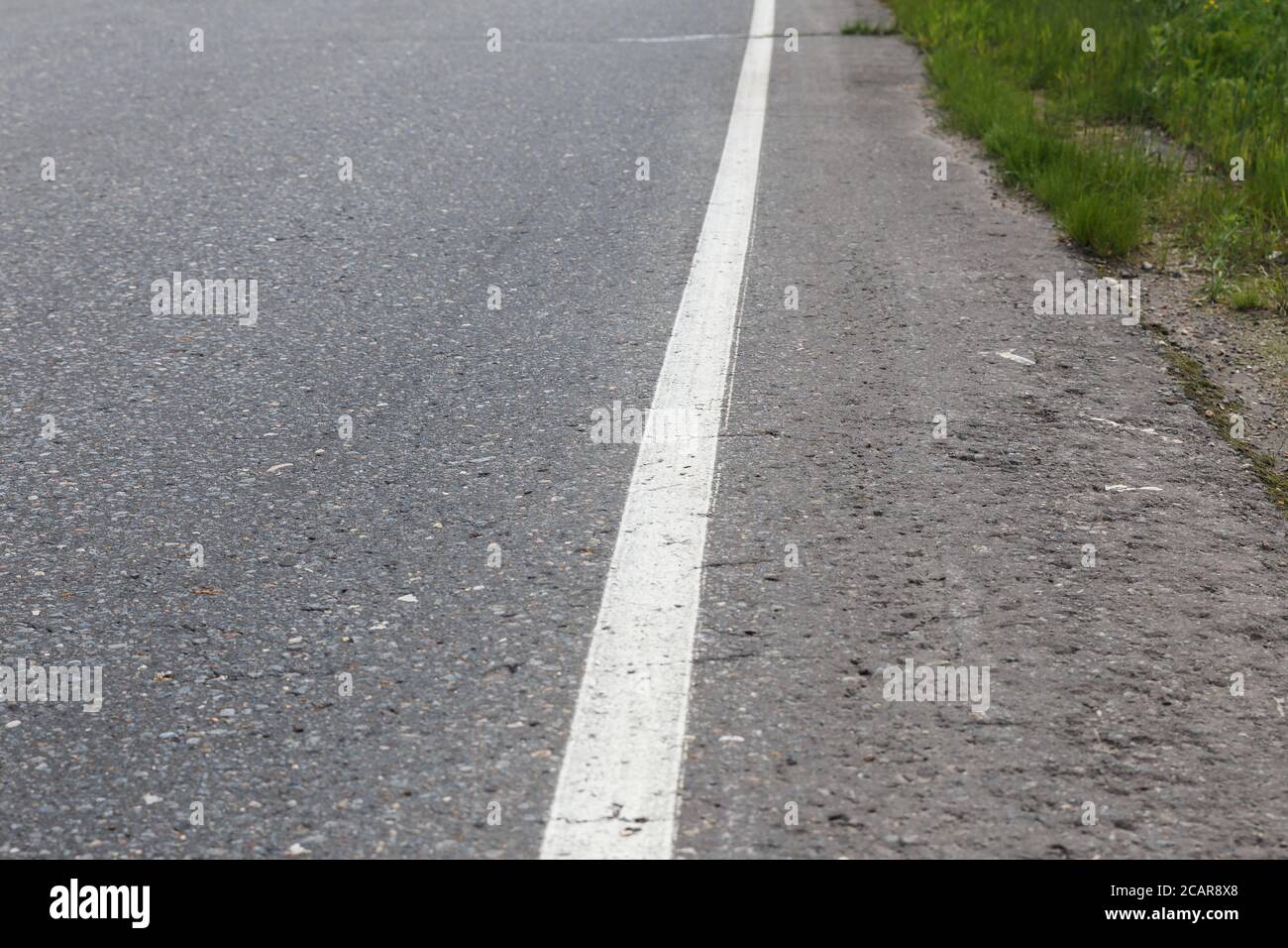 White solid line. Road marking on an asphalt road. selective focus ...