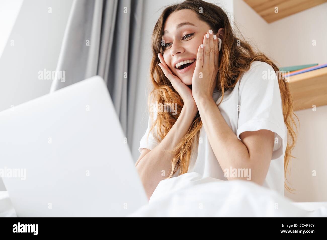 Portrait of excited woman with earphone expressing surprise and smiling ...