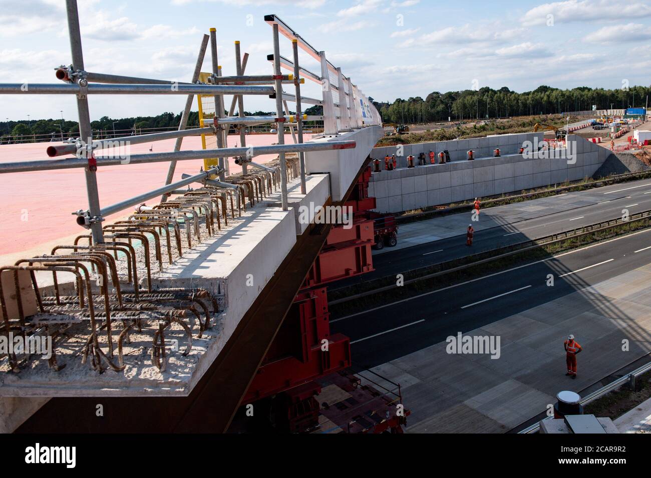 HS2 workers watch as a bridge is wheeled into position over the M42 at ...