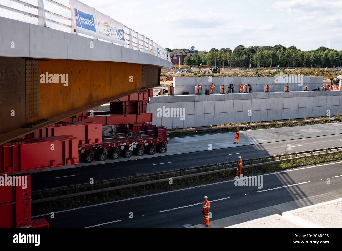 HS2 workers watch as a bridge is wheeled into position over the M42 at ...