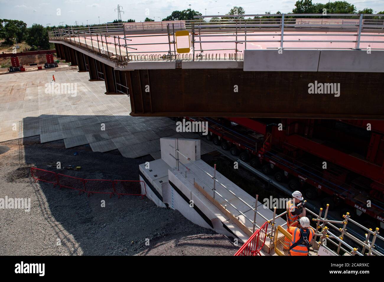 HS2 workers watch as a bridge is wheeled into position over the M42 at ...