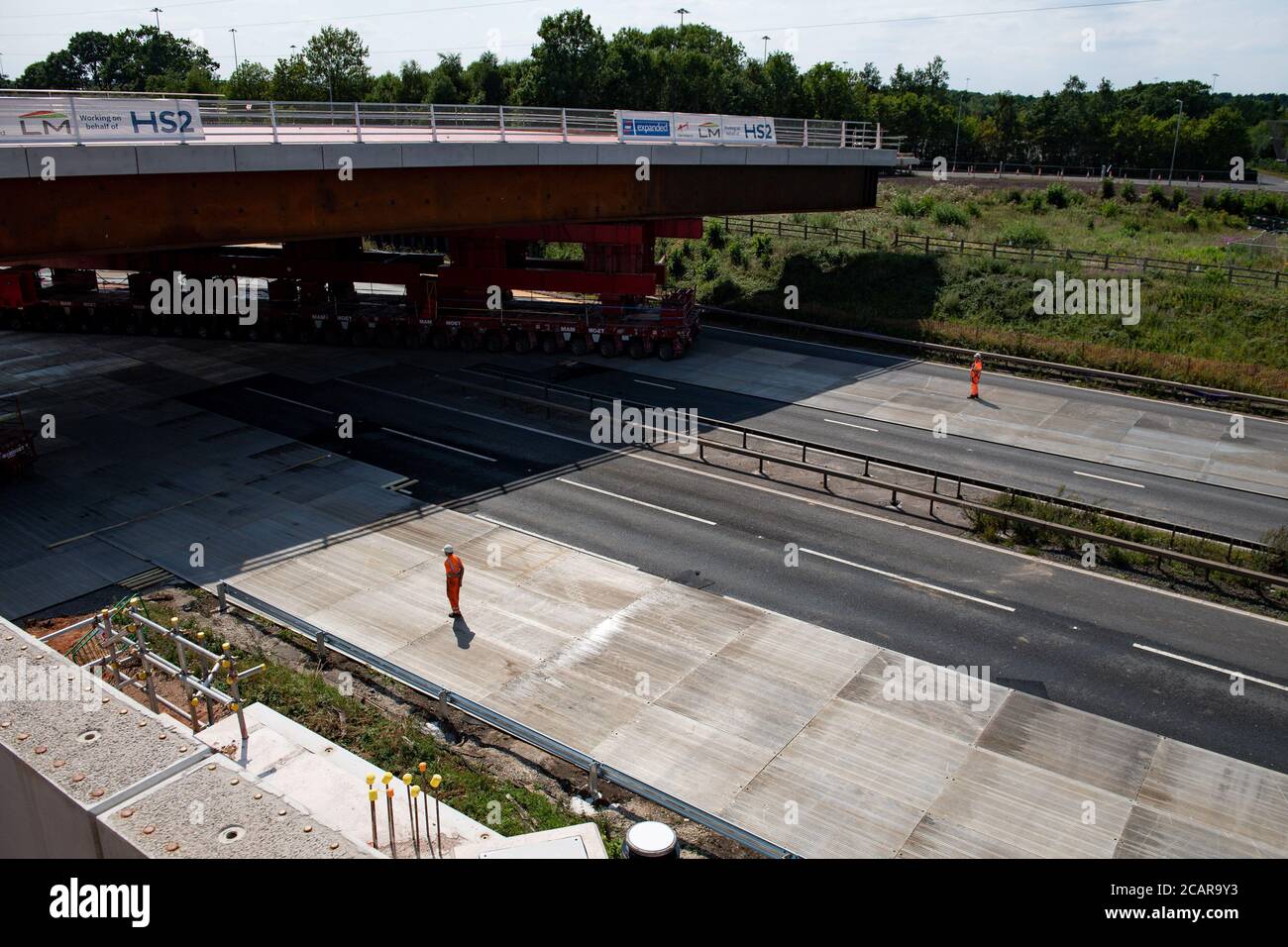 HS2 workers watch as a bridge is wheeled into position over the M42 at ...