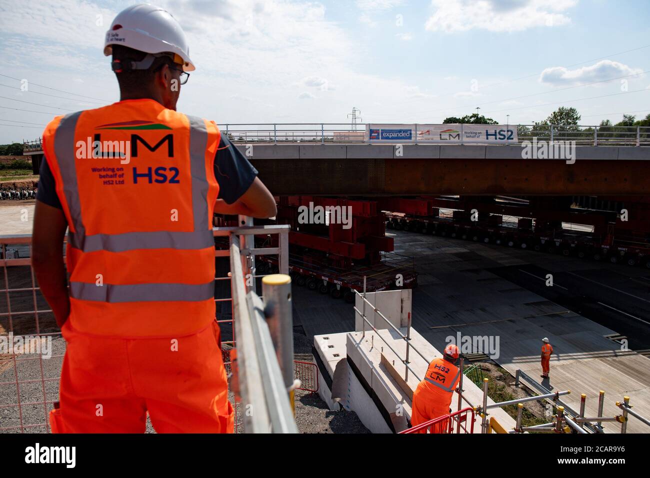 HS2 workers watch as a bridge is wheeled into position over the M42 at ...