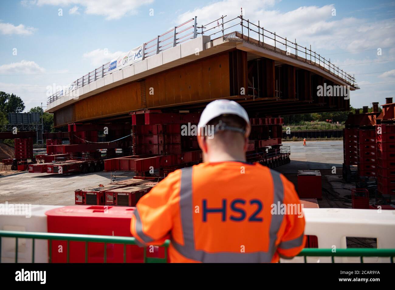 HS2 workers watch as a bridge is wheeled into position over the M42 at ...