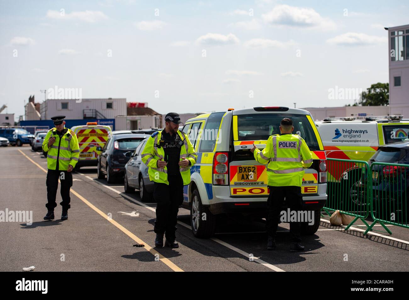 Police patrol the area as a bridge is prepared to be wheeled into ...