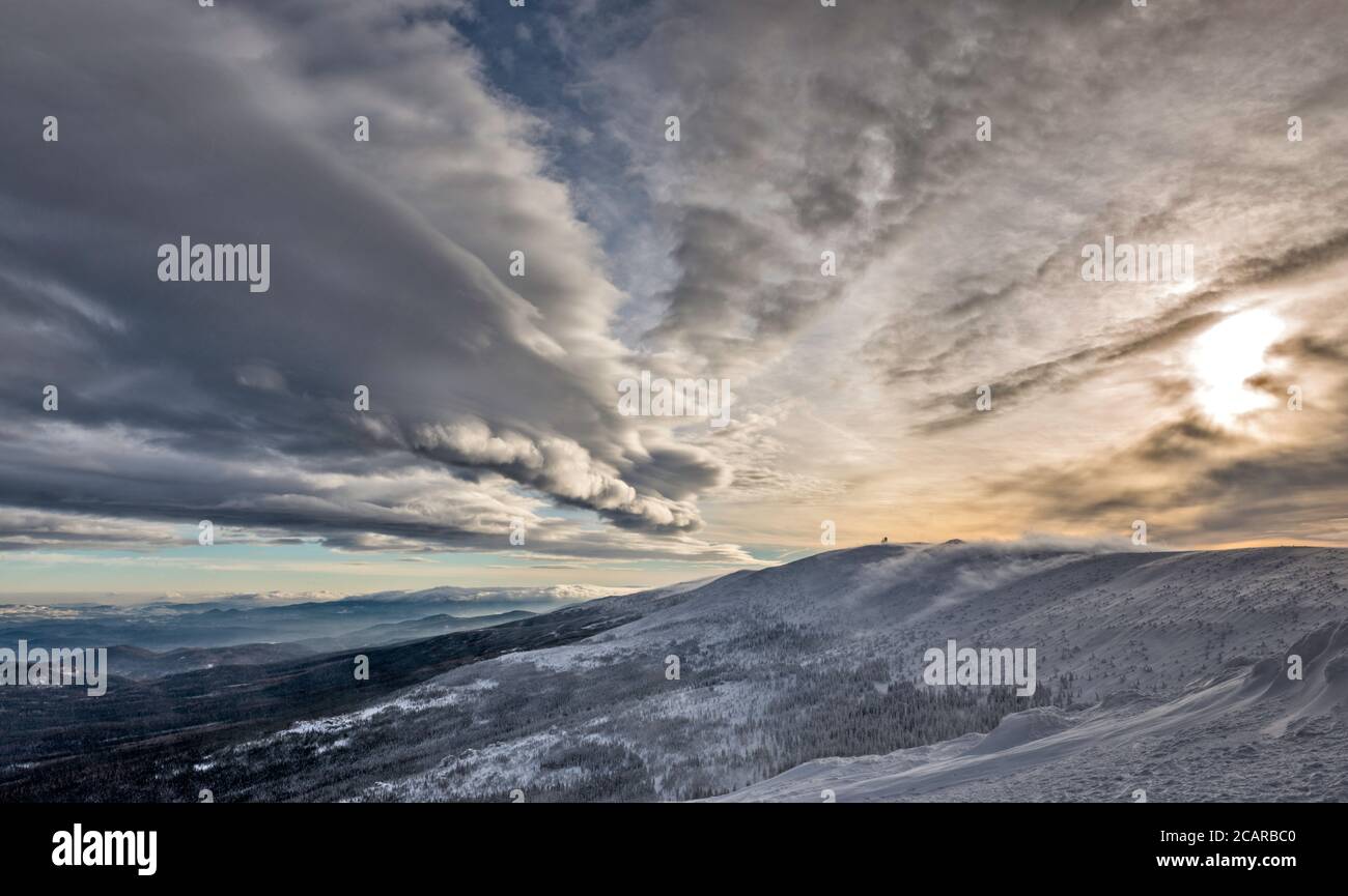Heavy storm clouds, snow falling in winter, with low foehn wind clouds ...
