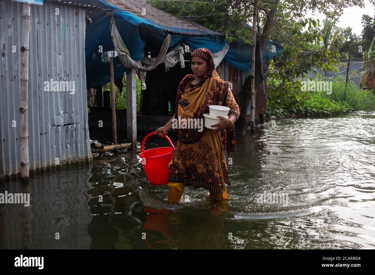 Dhaka, Dhaka, Bangladesh. 8th Aug, 2020. A woman carrying a bucket and ...