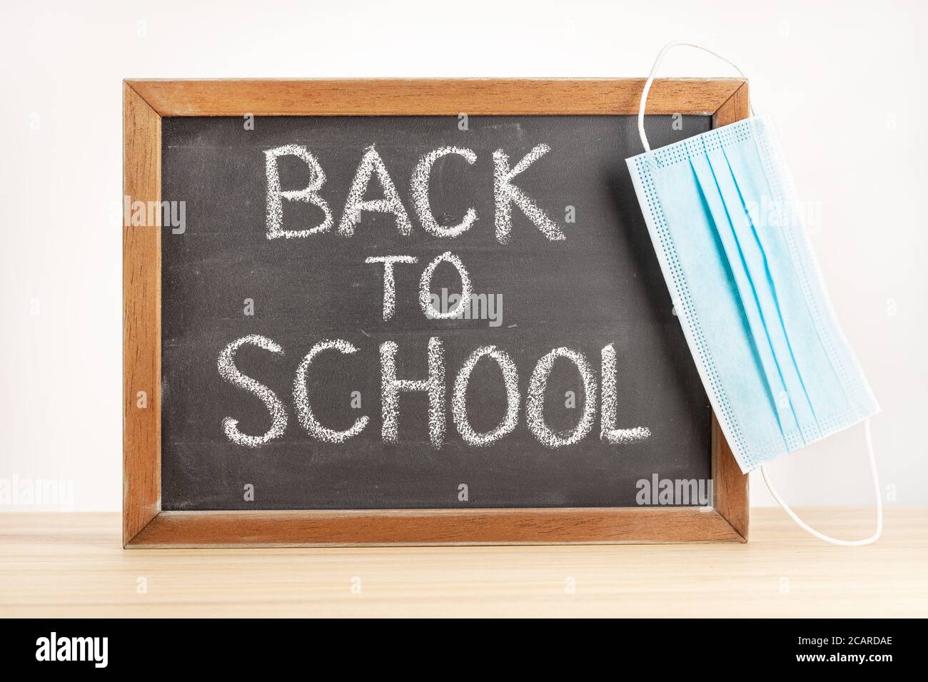 Return to school during covid-19 concept . Chalkboard with handwritten ...