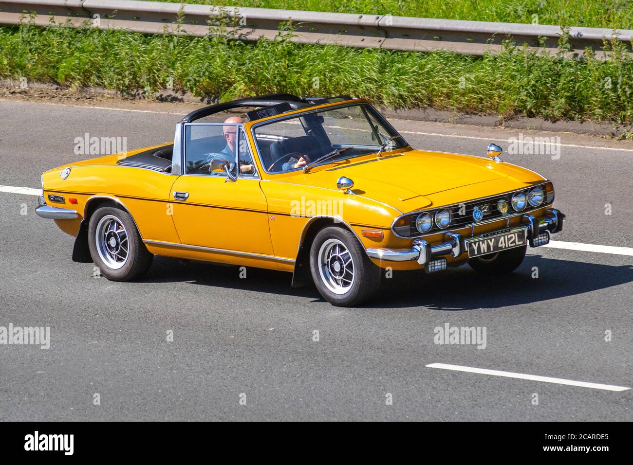 1972 70s yellow Triumph Stag 2997cc petrol ; Vehicular traffic moving ...