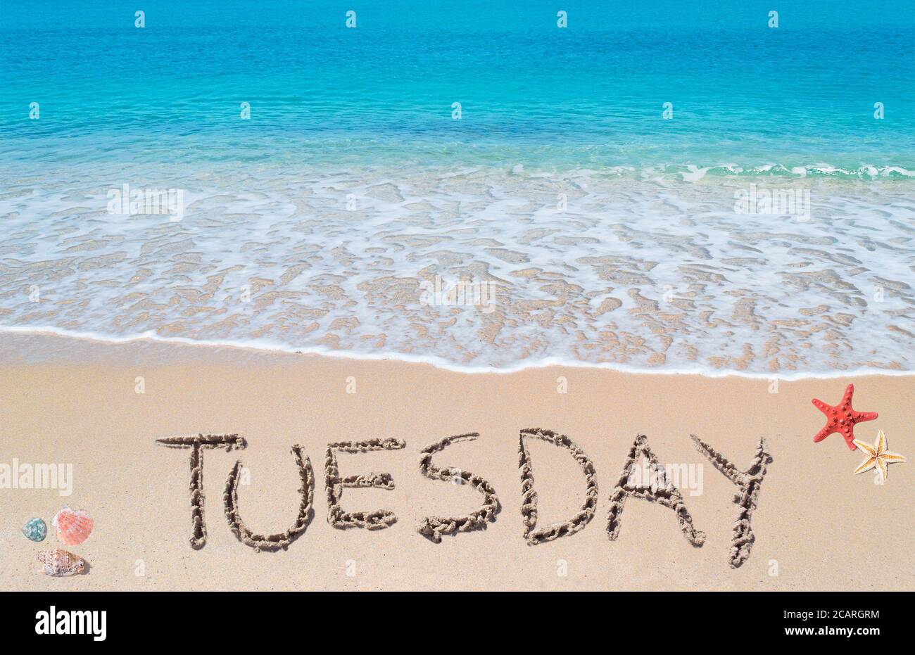 tuesday written on a tropical beach Stock Photo - Alamy