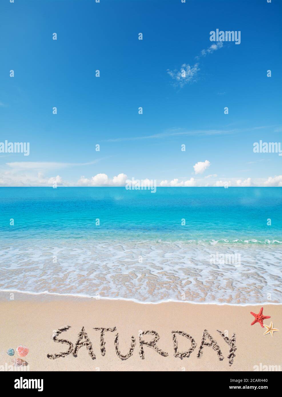 saturday written on a tropical beach under clouds Stock Photo - Alamy