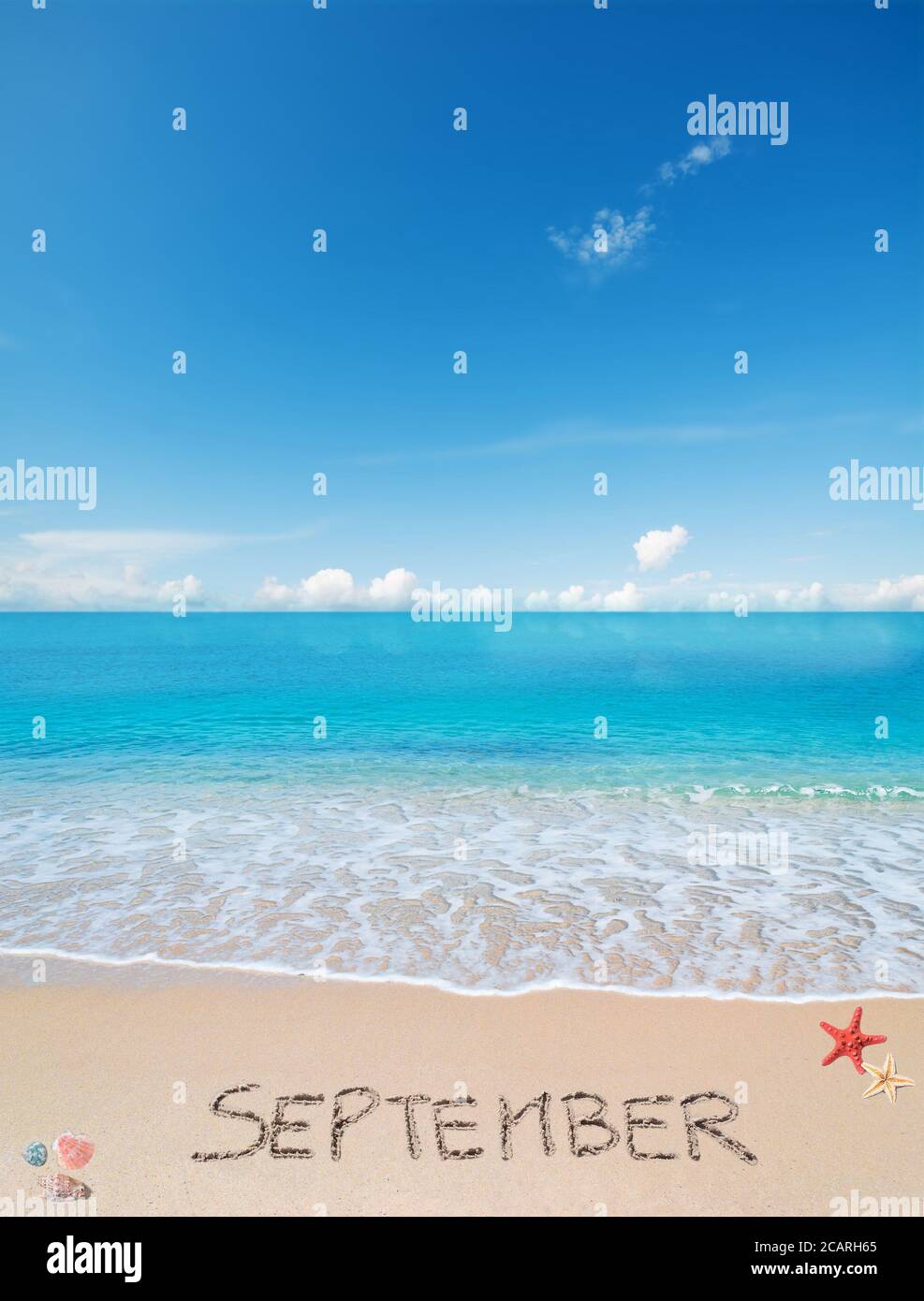 september written on a tropical beach under clouds Stock Photo - Alamy