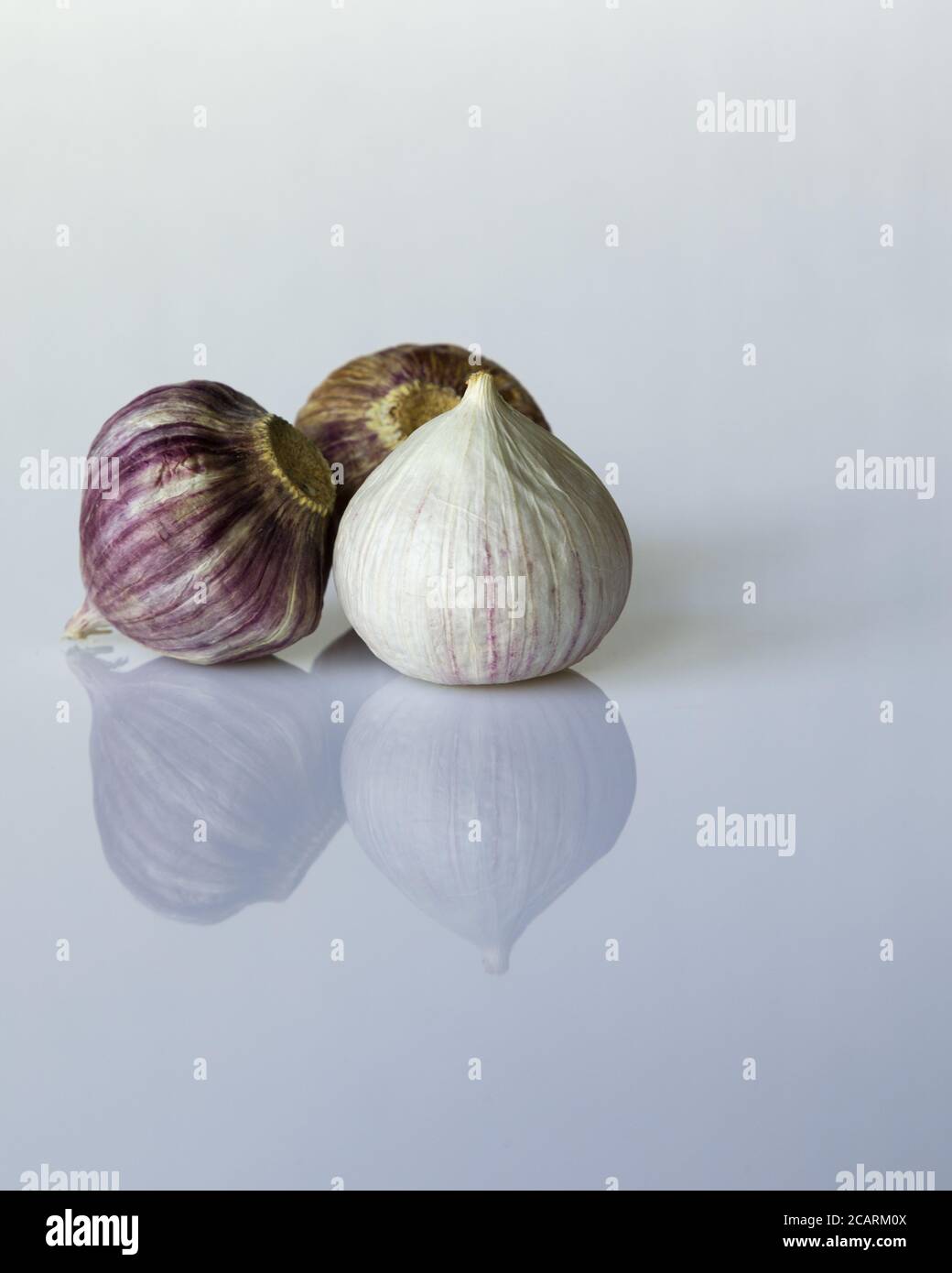 Fresh Solo garlic bulbs in a basket on a white background. They are ...