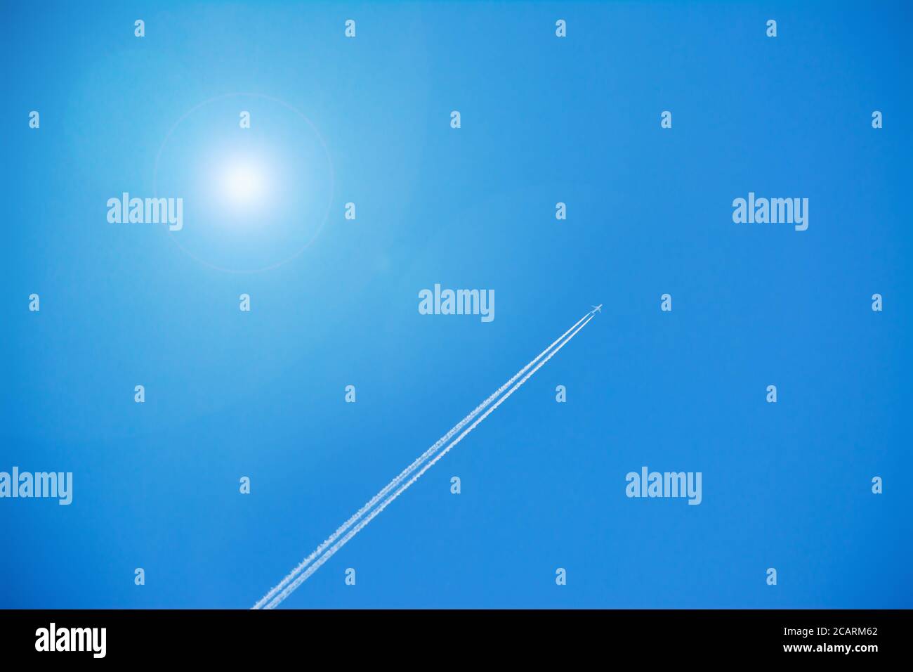 airplane contrails under a shining sun on a clear summer day Stock ...
