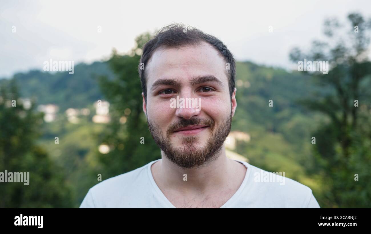 Young white-skinned man looking at camera, smiling confidently and ...