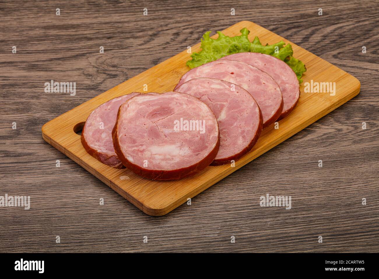 Slices of pork meat ham over wooden board Stock Photo - Alamy