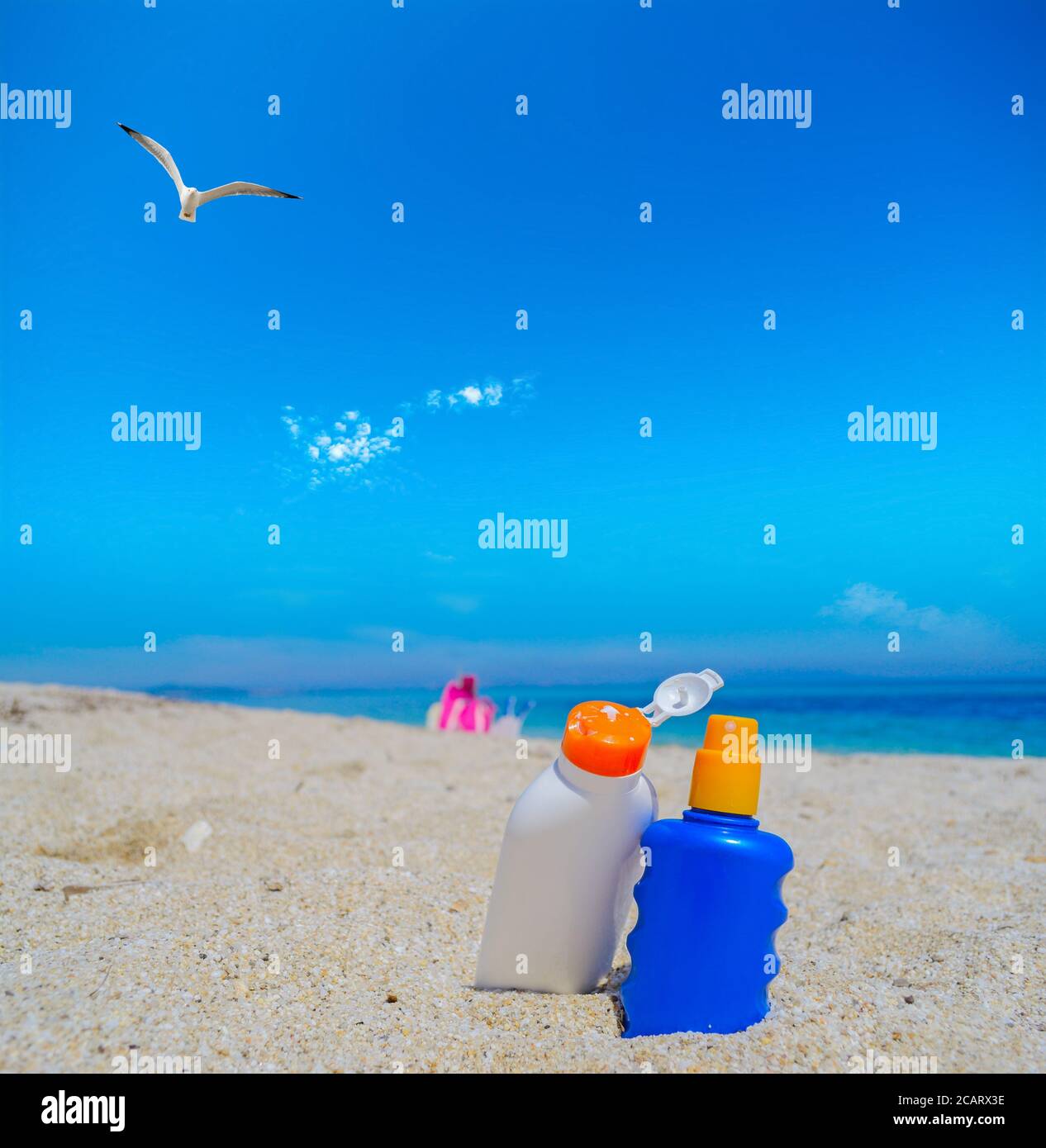 seagull flying over the suntan lotion bottles on a white sand Stock ...