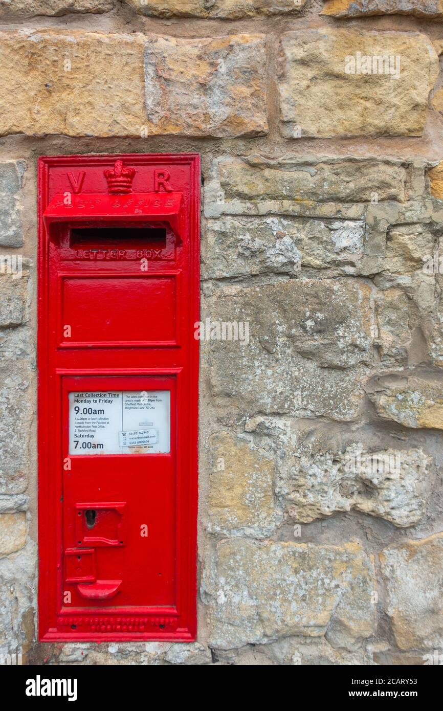 traditional old fashioned red letterbox built into stone wall building ...