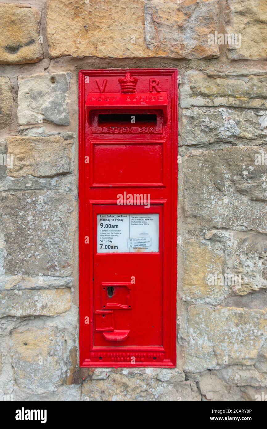 traditional old fashioned red letterbox built into stone wall building ...