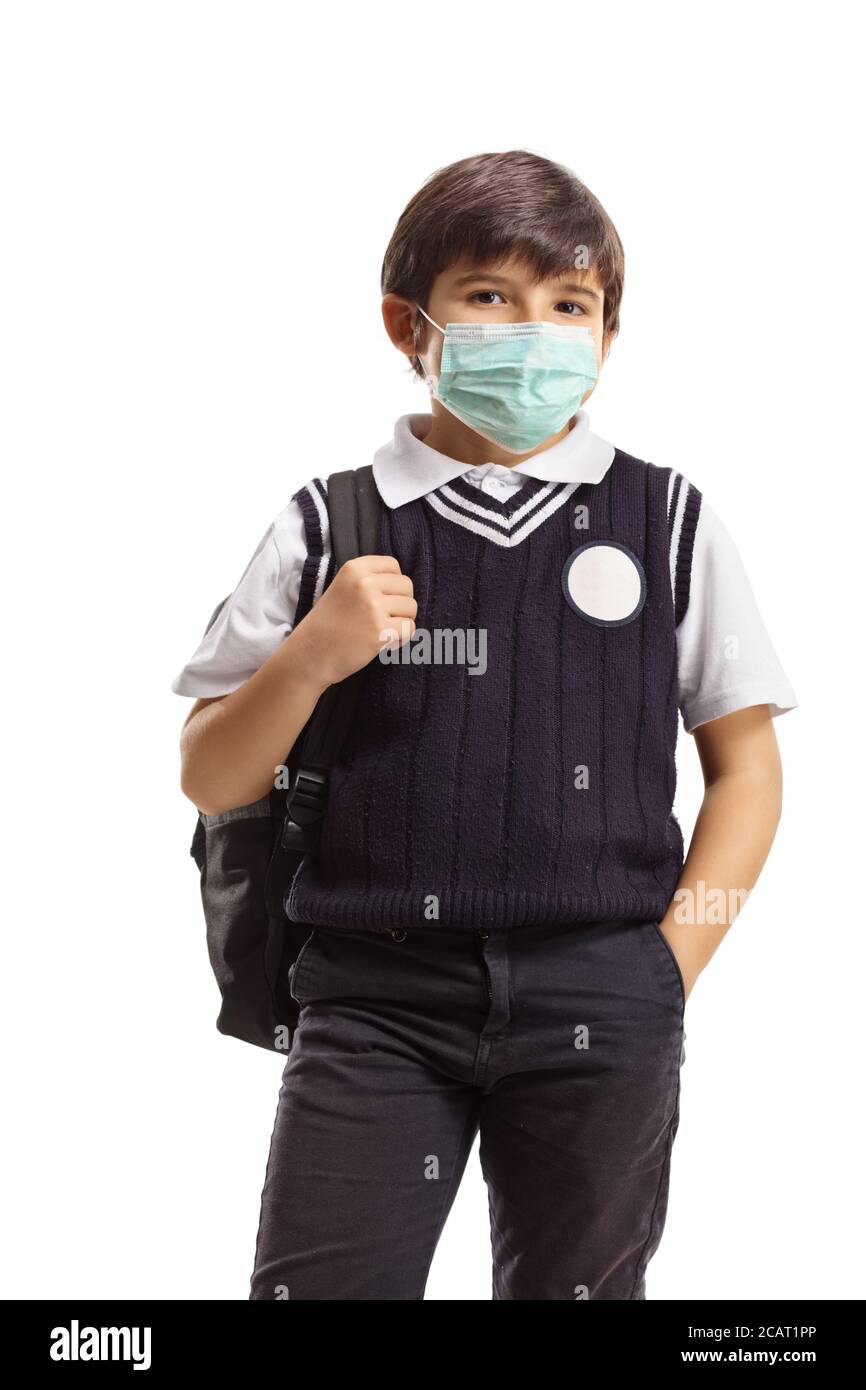 Schoolboy in a uniform wearing a protective face mask and posing ...