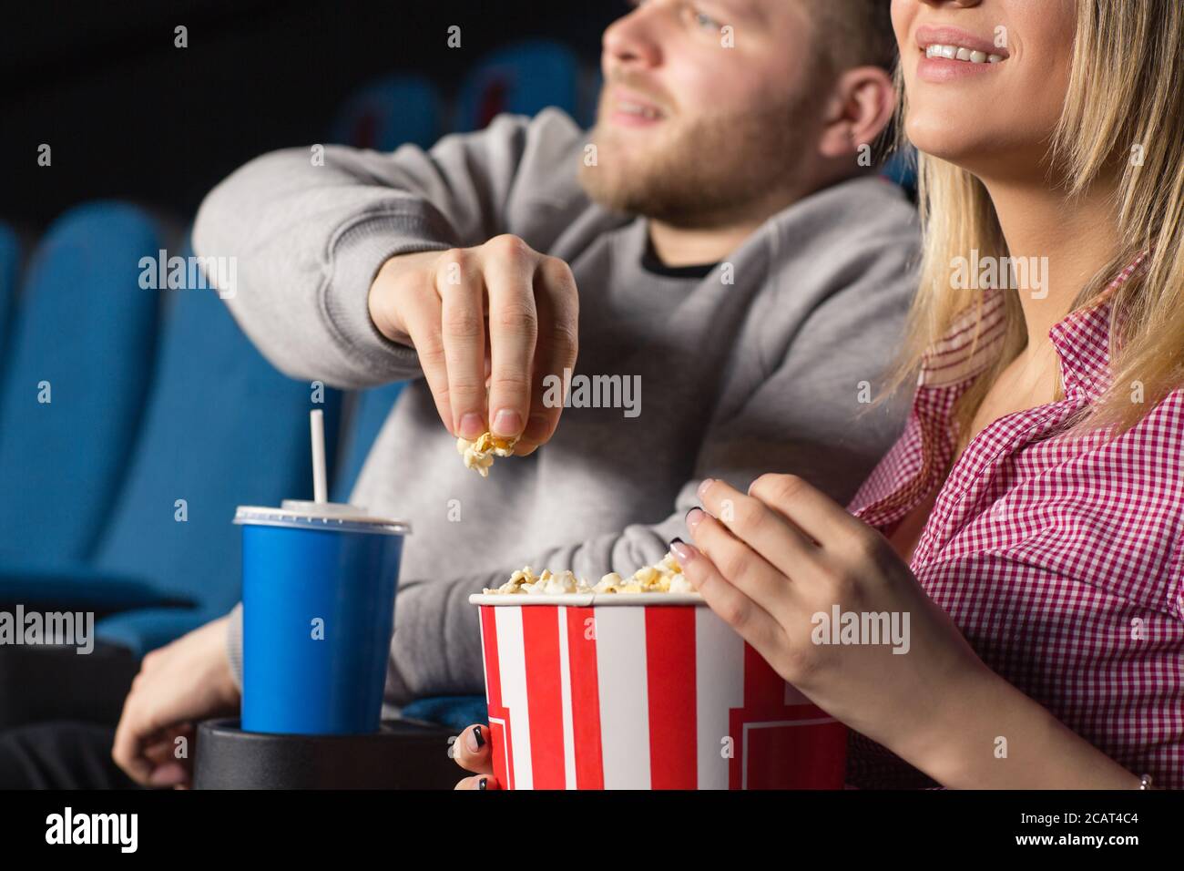 Loving the movie. Cropped closeup of a happy smiling couple eating ...