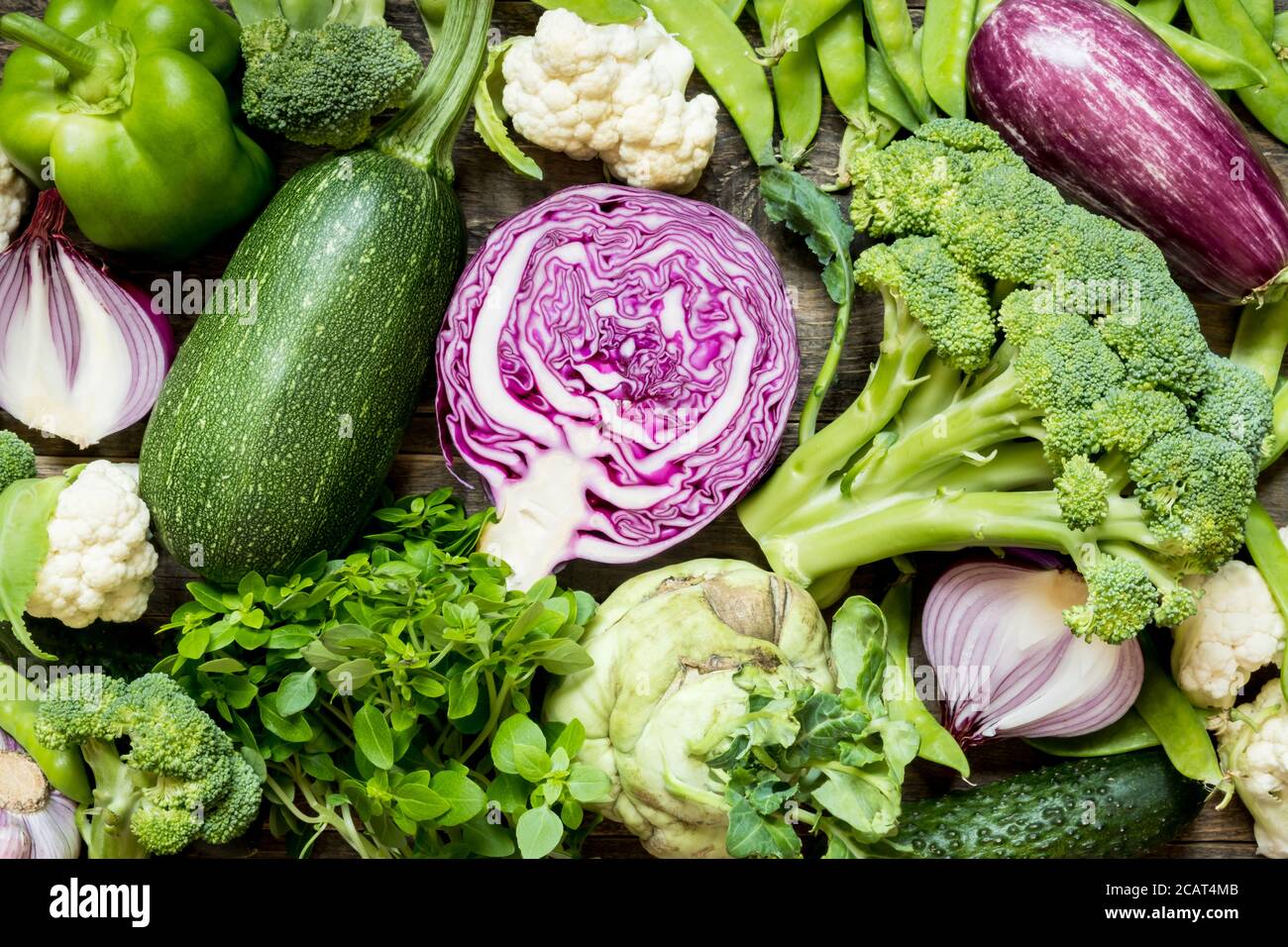 Top view set raw of green, red and purple vegetables spread on dark ...