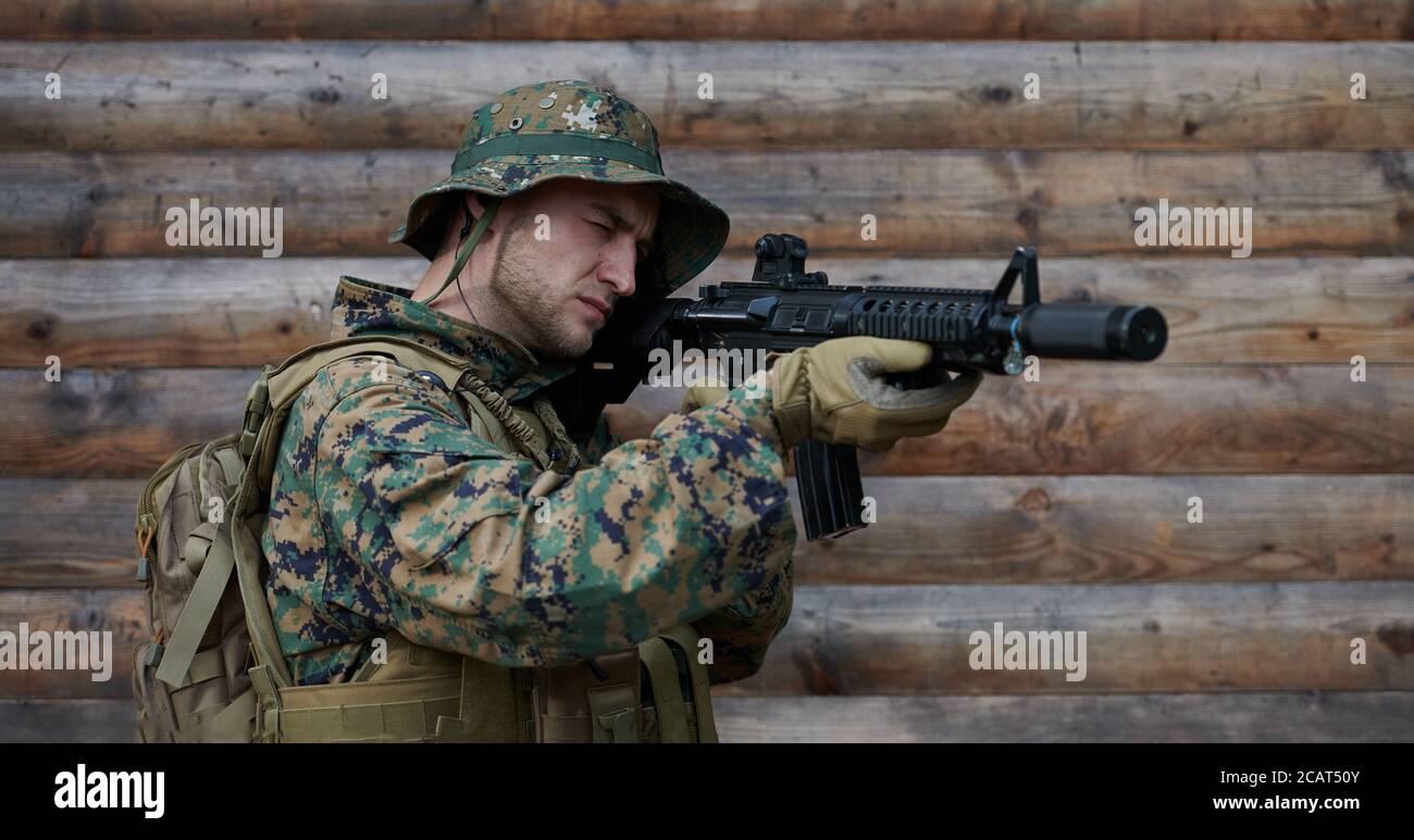 modern warfare soldier in action aiming at weapon laser sight optics in ...