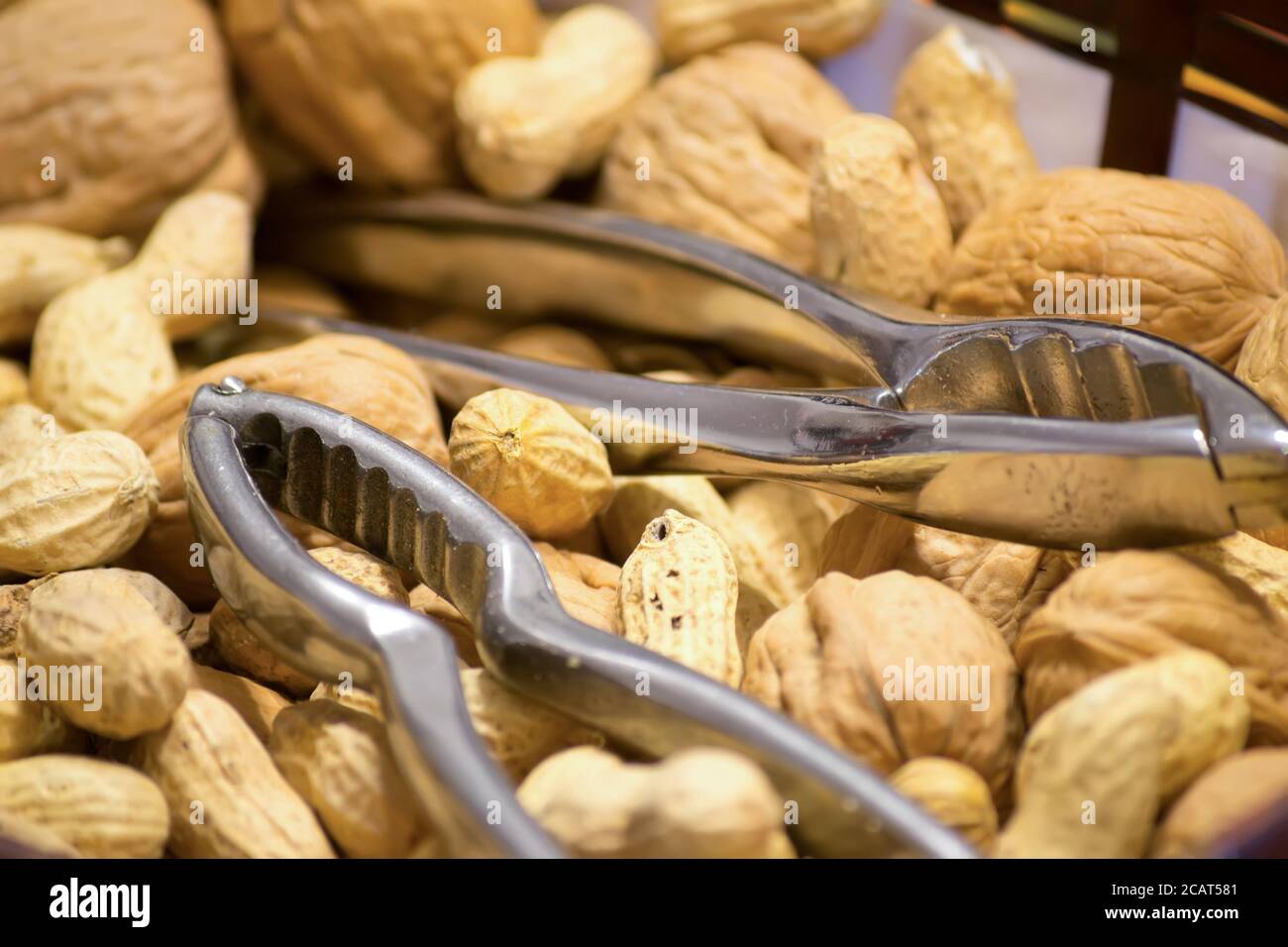 two metal nutcrackers on a bunch of peanuts Stock Photo - Alamy