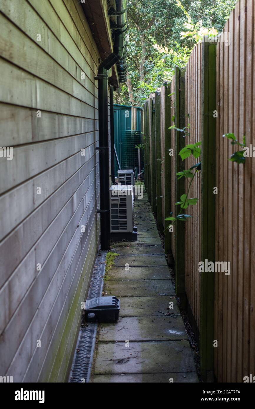 narrow dark alleyway between building and fencing Stock Photo - Alamy