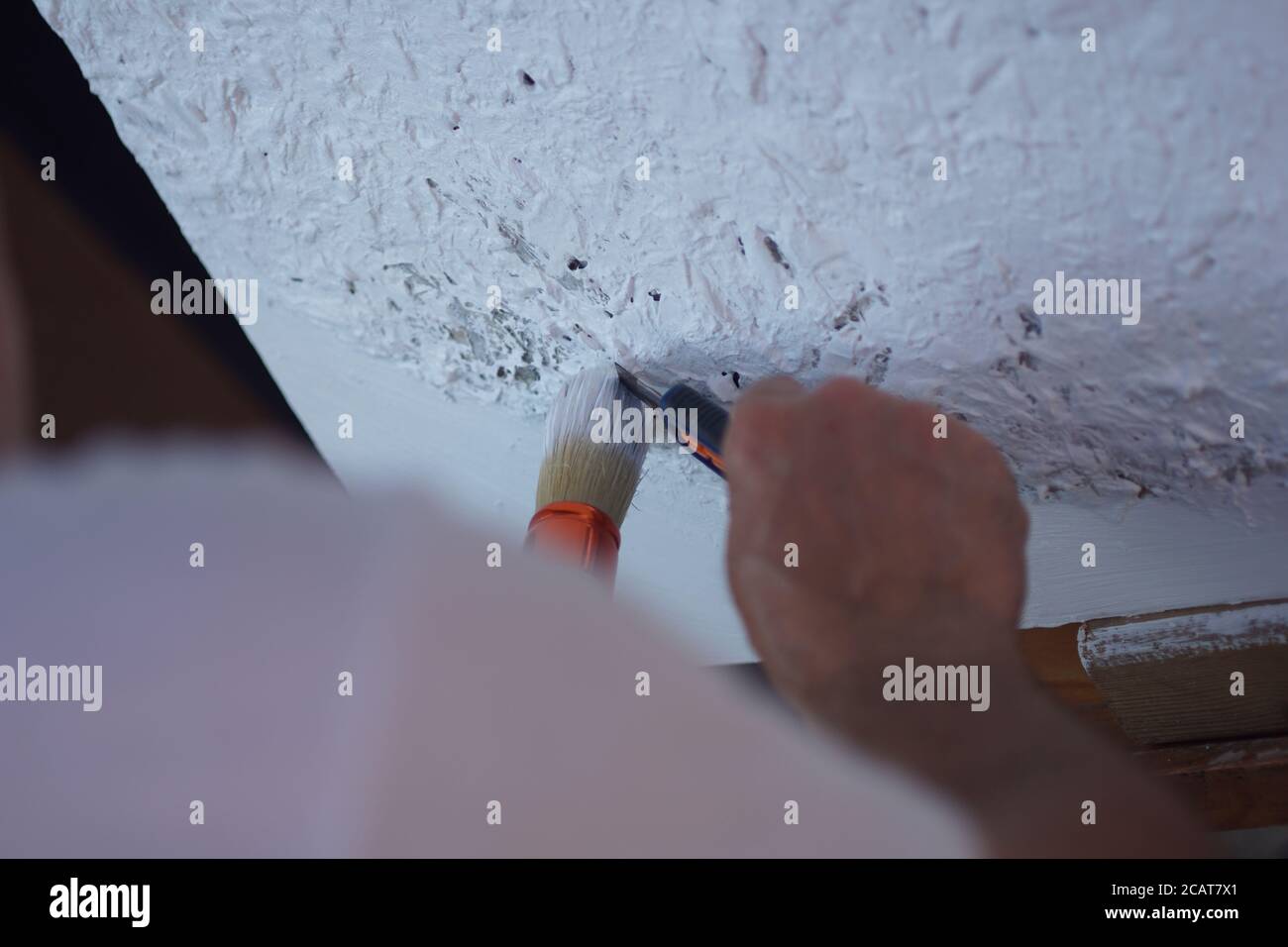 Closeup of a professional artist creating art with white paint and a ...