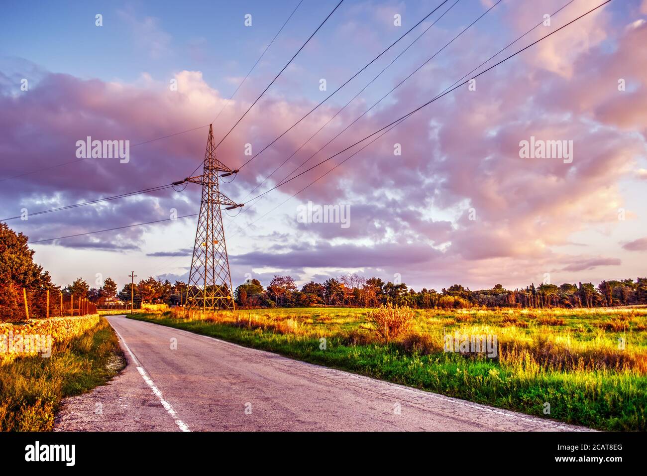 electricity pylons by a country road at dusk Stock Photo - Alamy