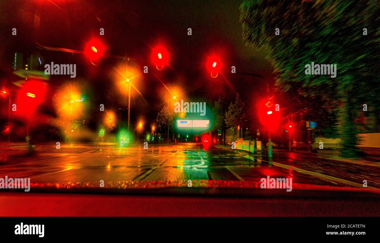 View through a front window of a car at the night stop at a colorful ...