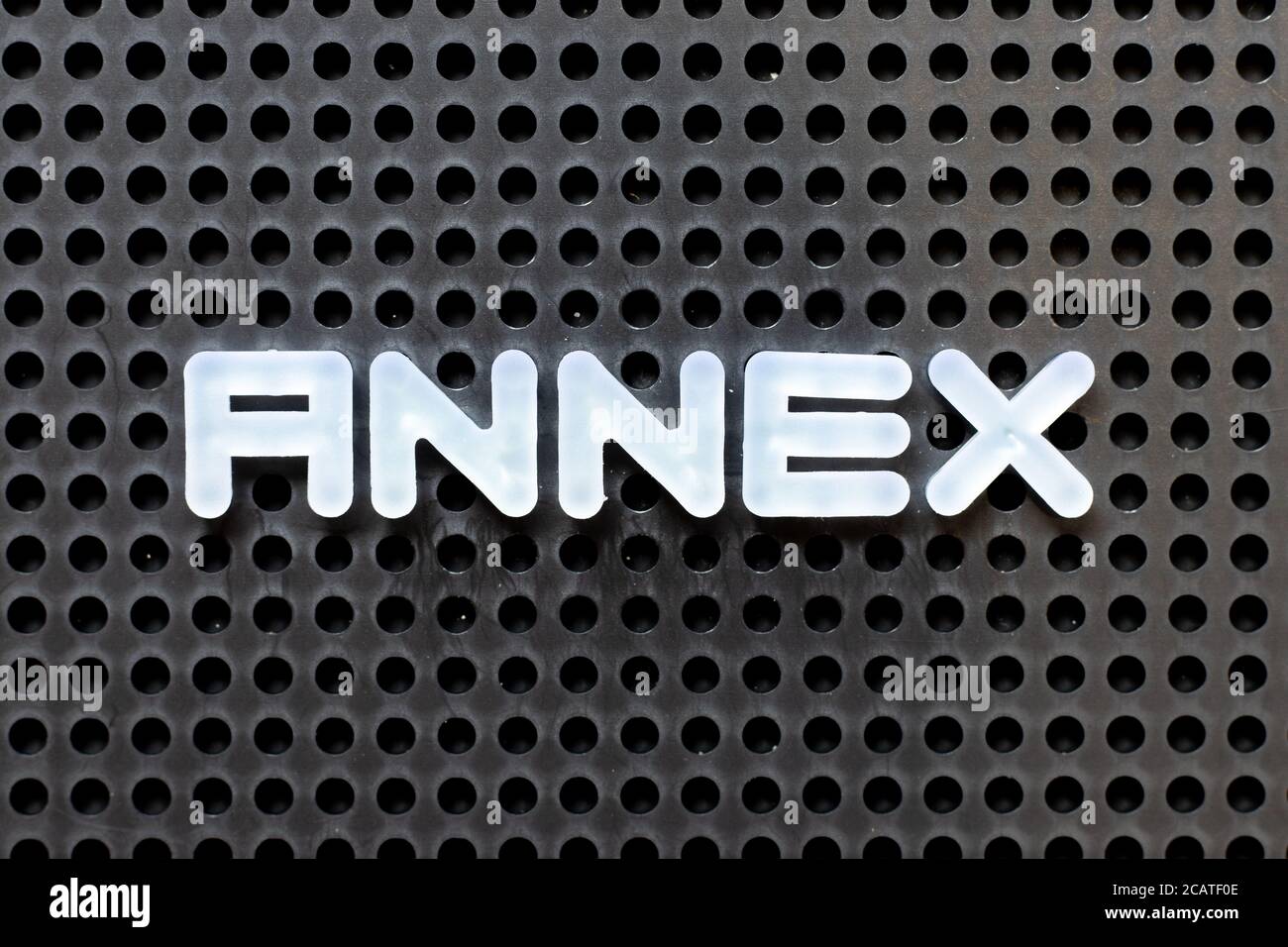 White color alphabet with word annex on black pegboard background Stock ...
