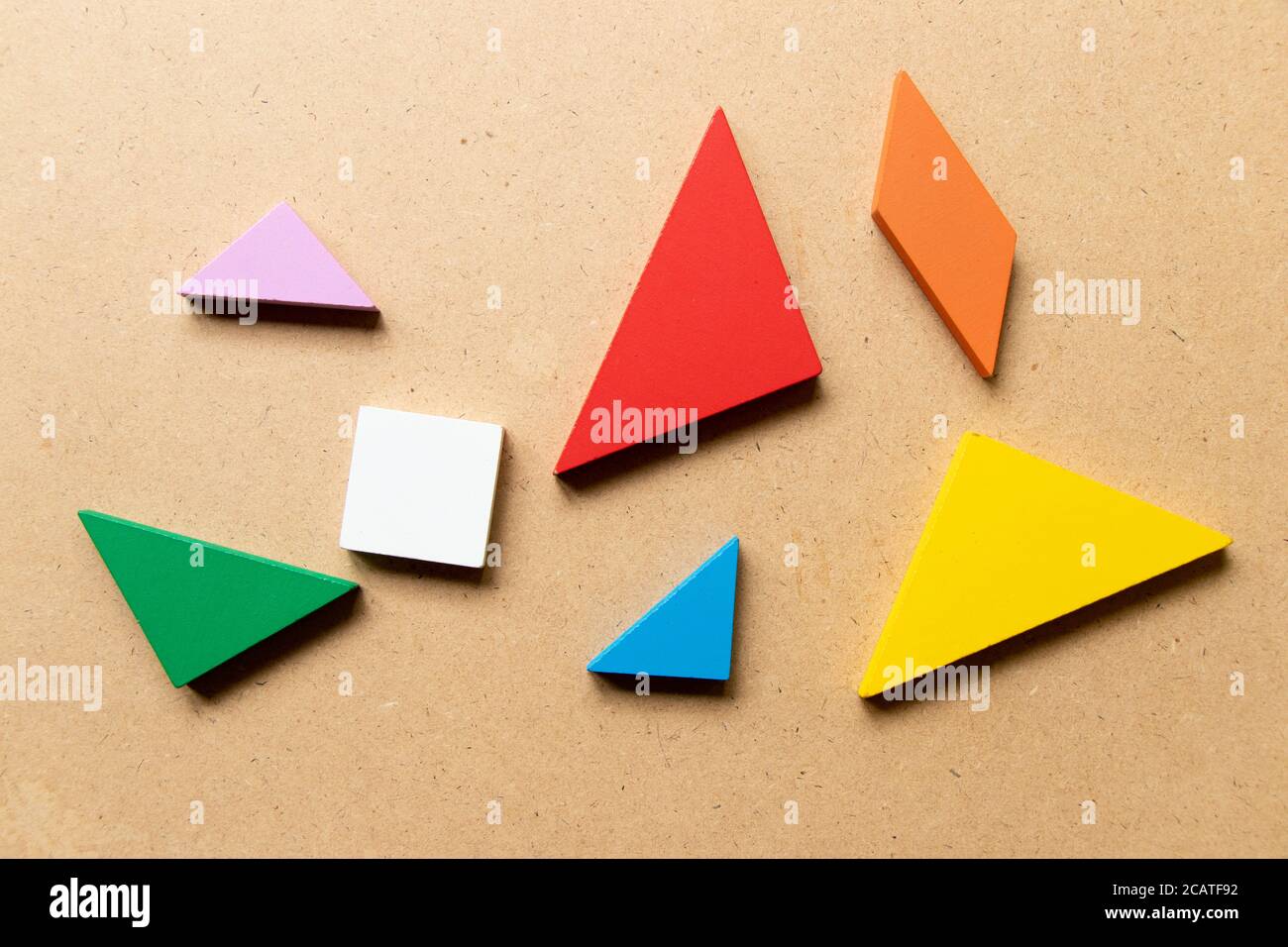Color tangram puzzle in piece that wait to complete shape on wood ...