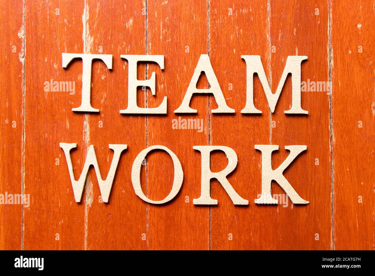 Alphabet letter in word teamwork on old red color wood plate background ...