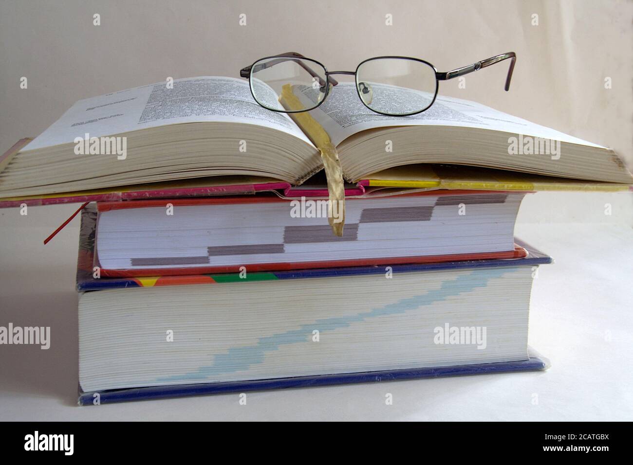 Reading glass placed on open book in white background Stock Photo - Alamy
