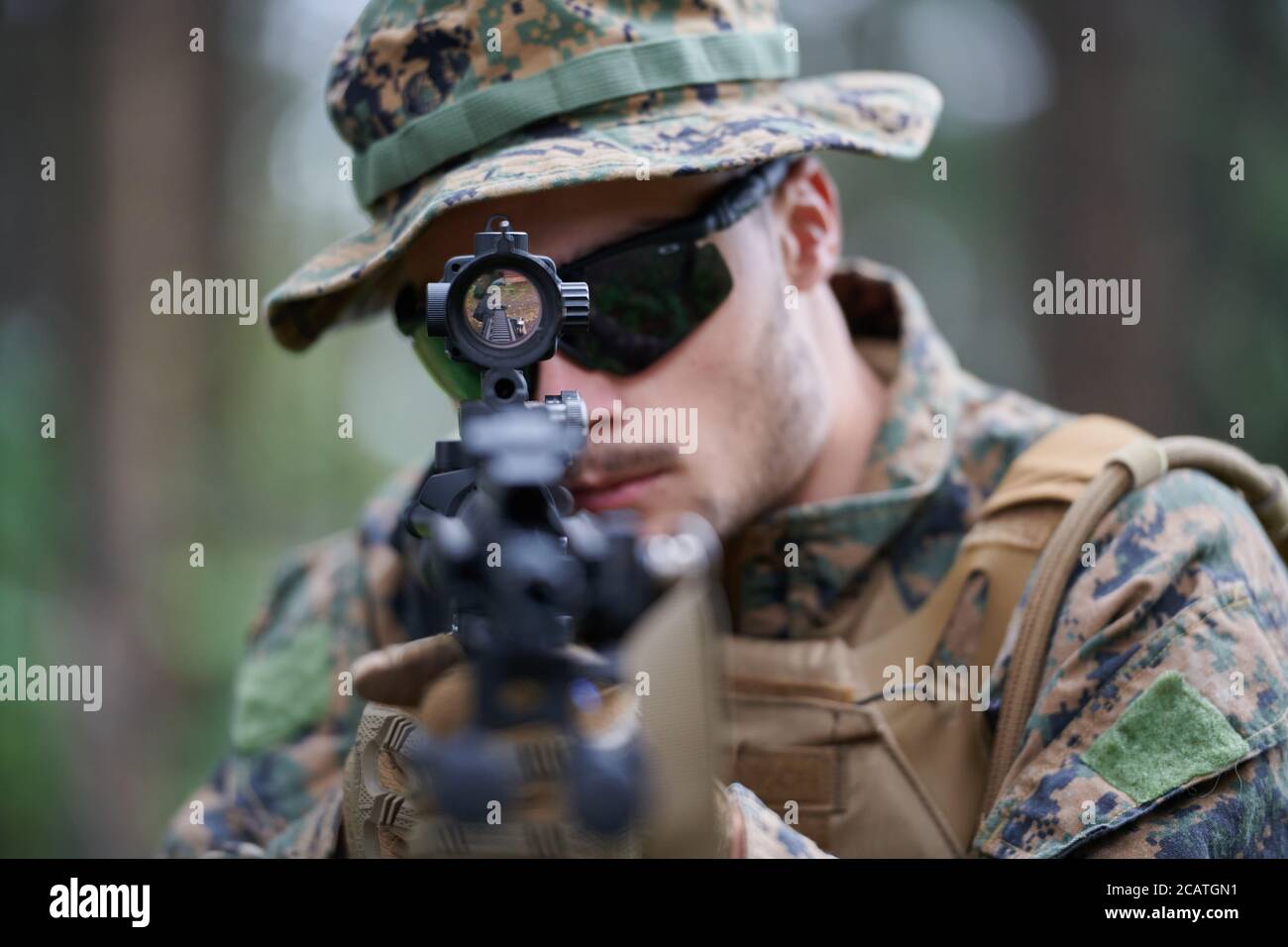 modern warfare soldier in action aiming at weapon laser sight optics in ...