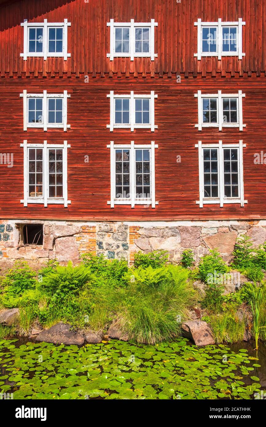 Old red wooden building with windows by a stream Stock Photo - Alamy