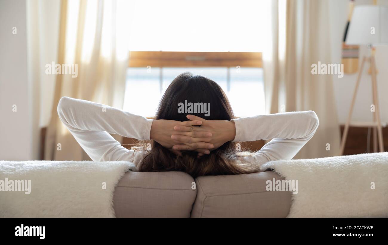 Serene young woman enjoying quiet moment on couch Stock Photo - Alamy