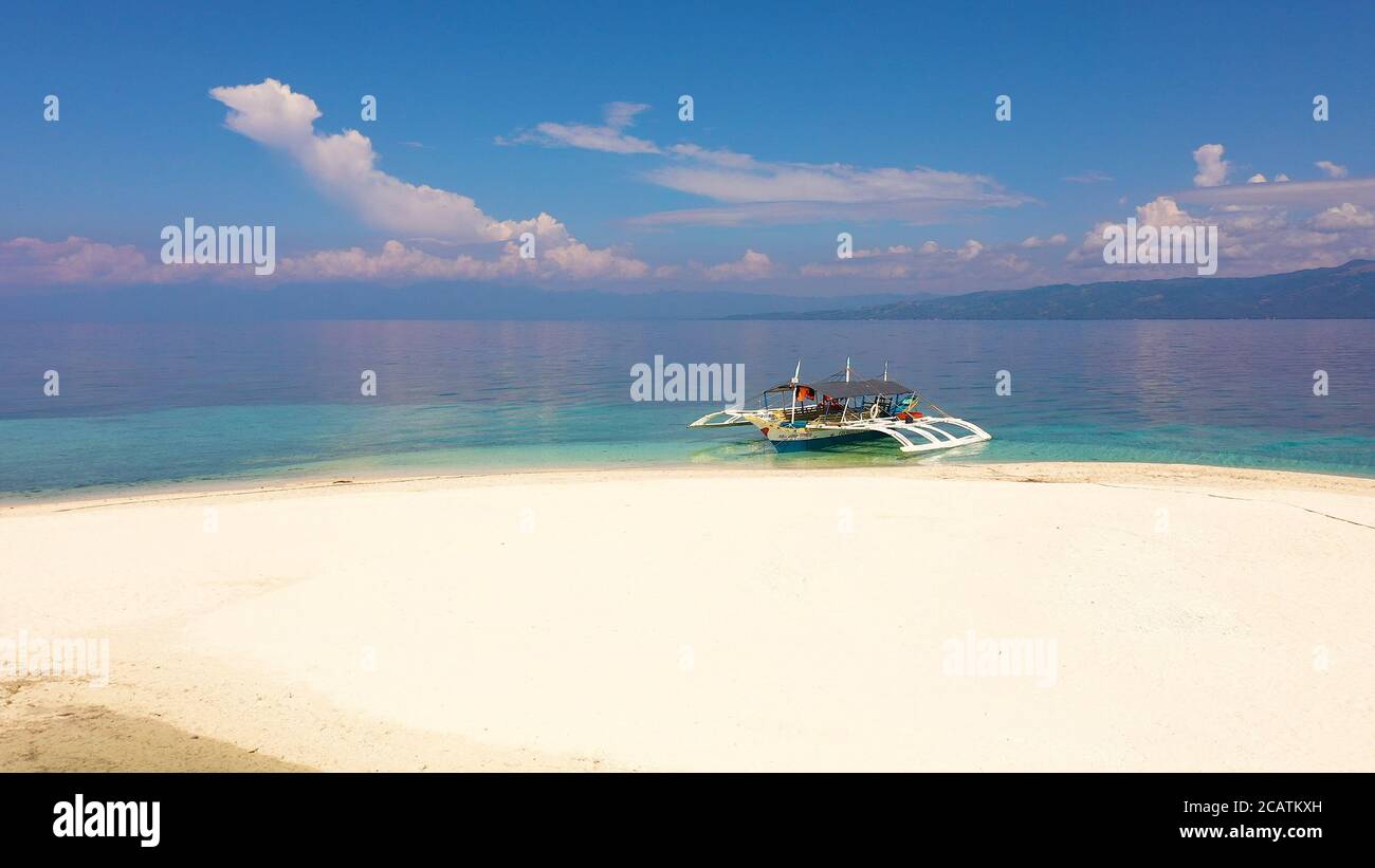 Perfect beach with blue water and white sand. Boat off the coast of a ...