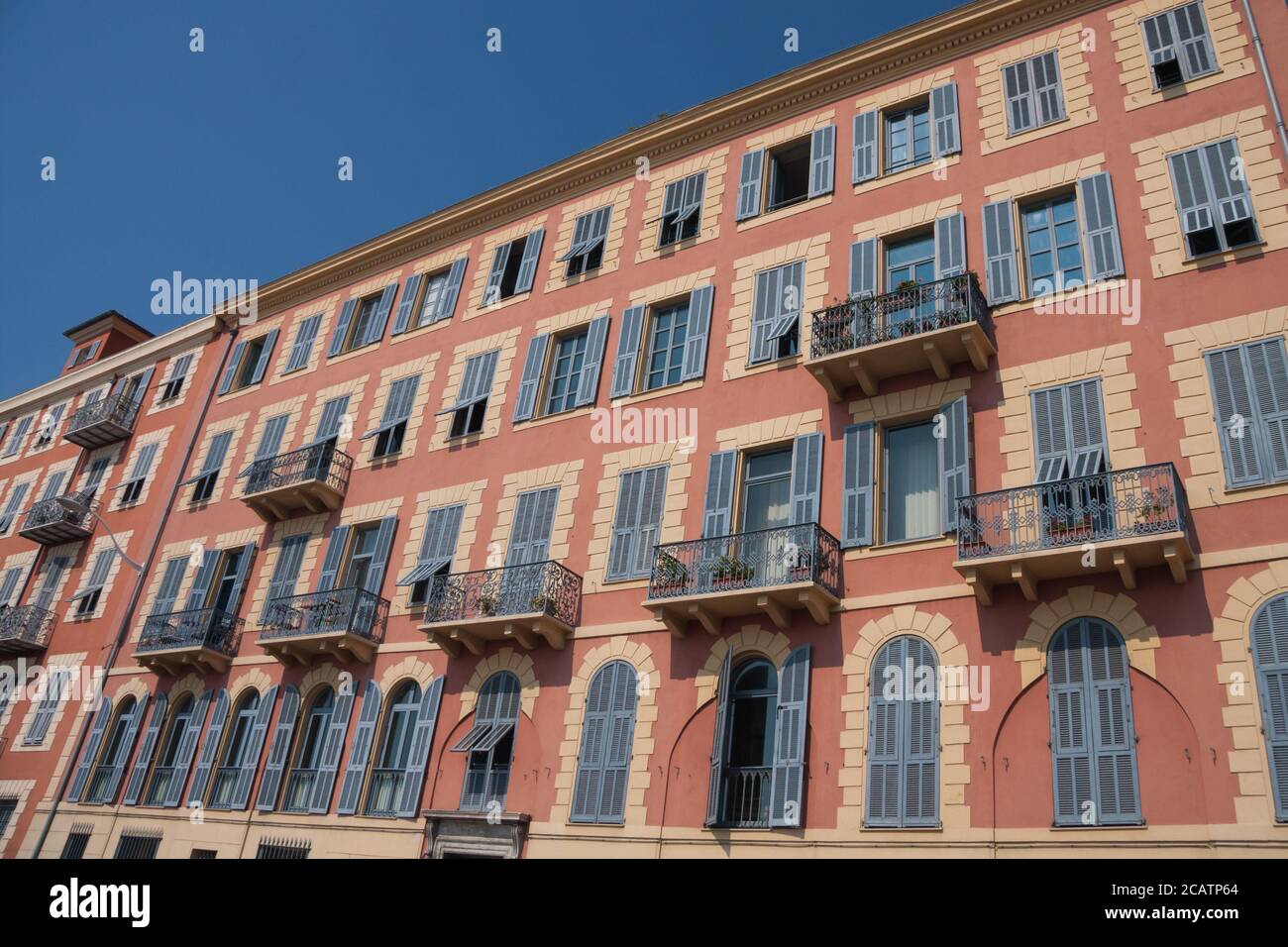 Traditional colorful painted building with blue shutters and balconies ...