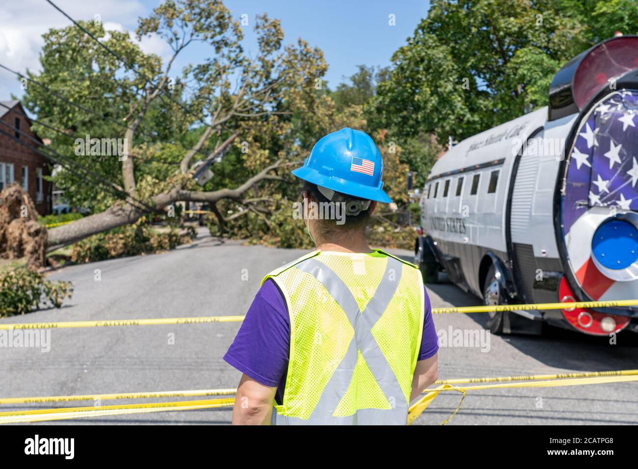 NEW YORK, NY - AUGUST 08: A ConEd worker looks at a downed tree and ...