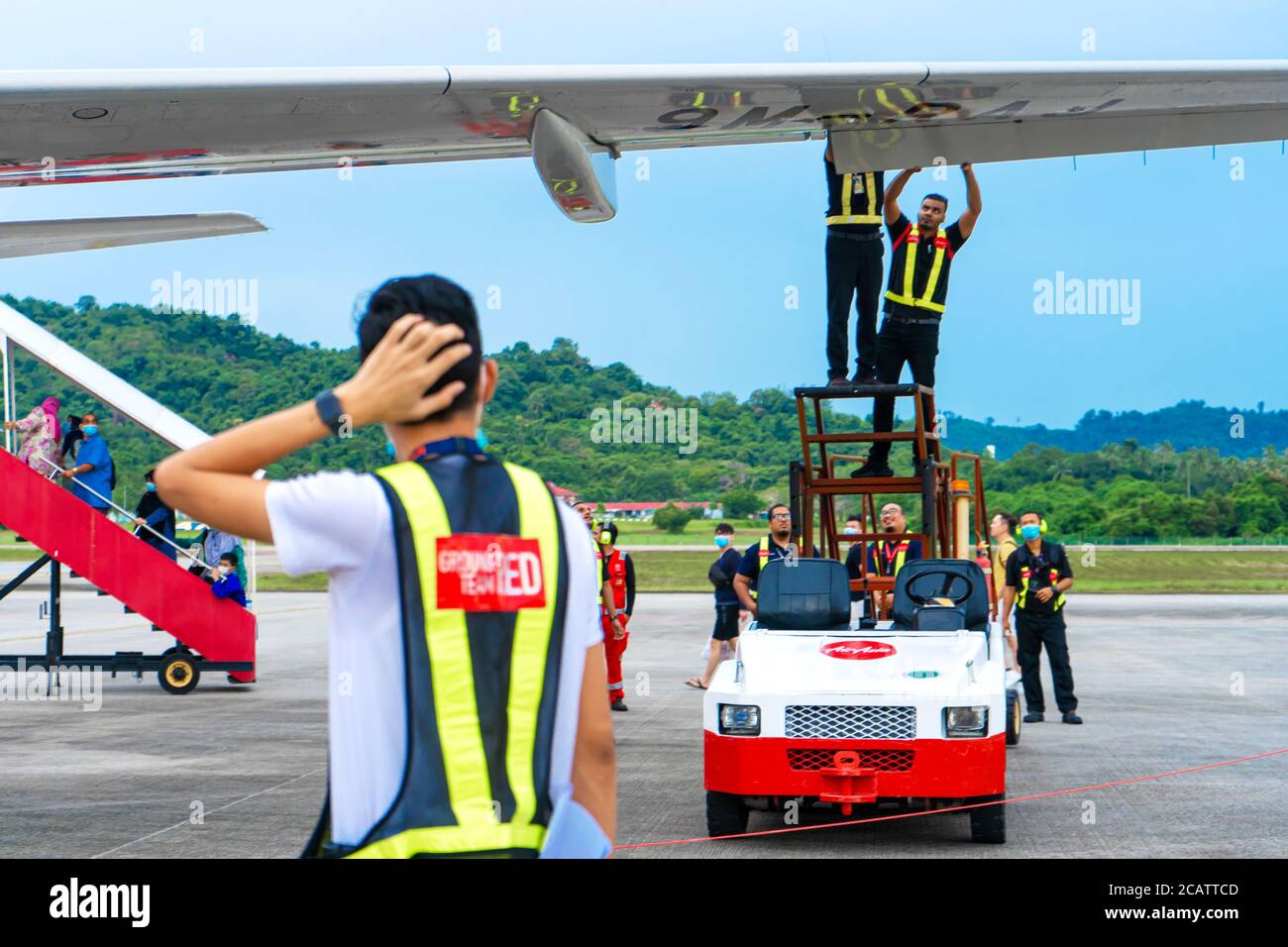 An avionics technician watches in confusion as airport technician team ...